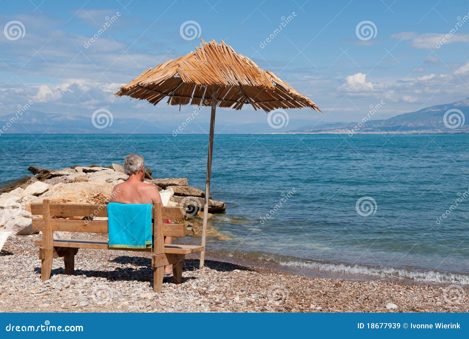 Greek beach with man stock image. Image of water, sitting - 18677939