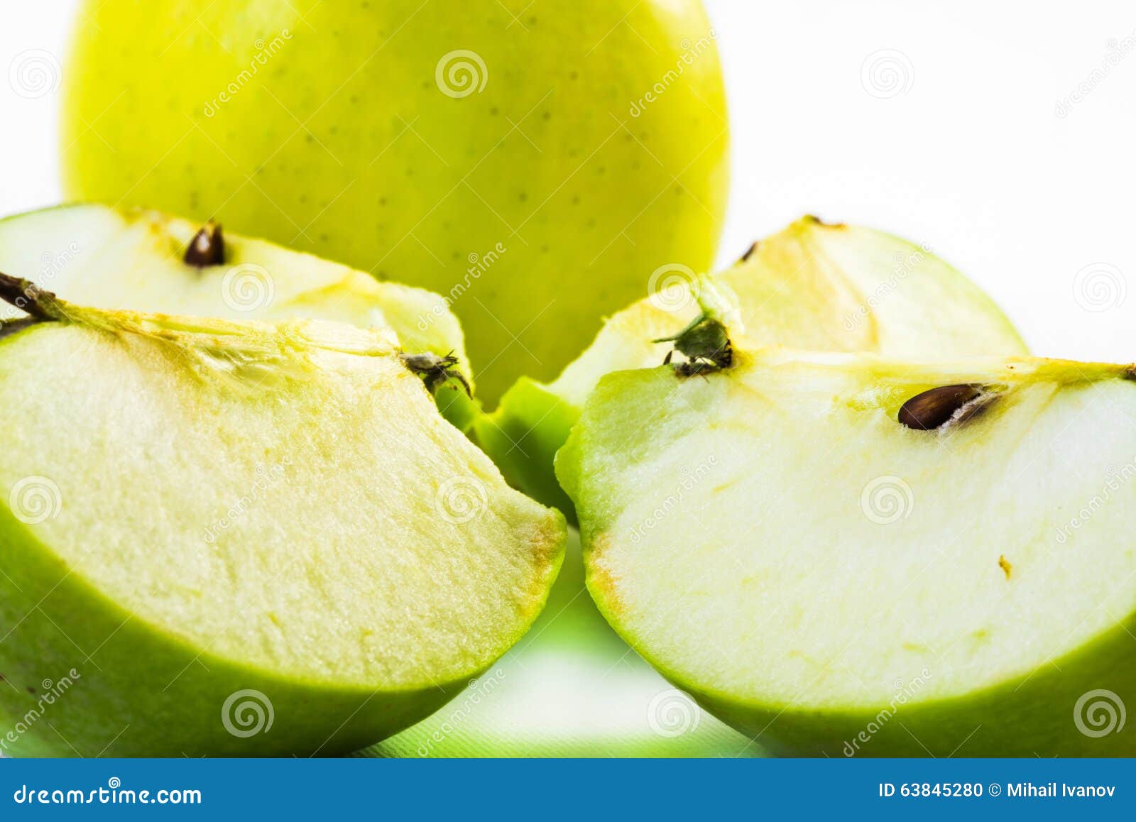 Green Apple Sliced in Four Pieces and an Apple on a White Background ...