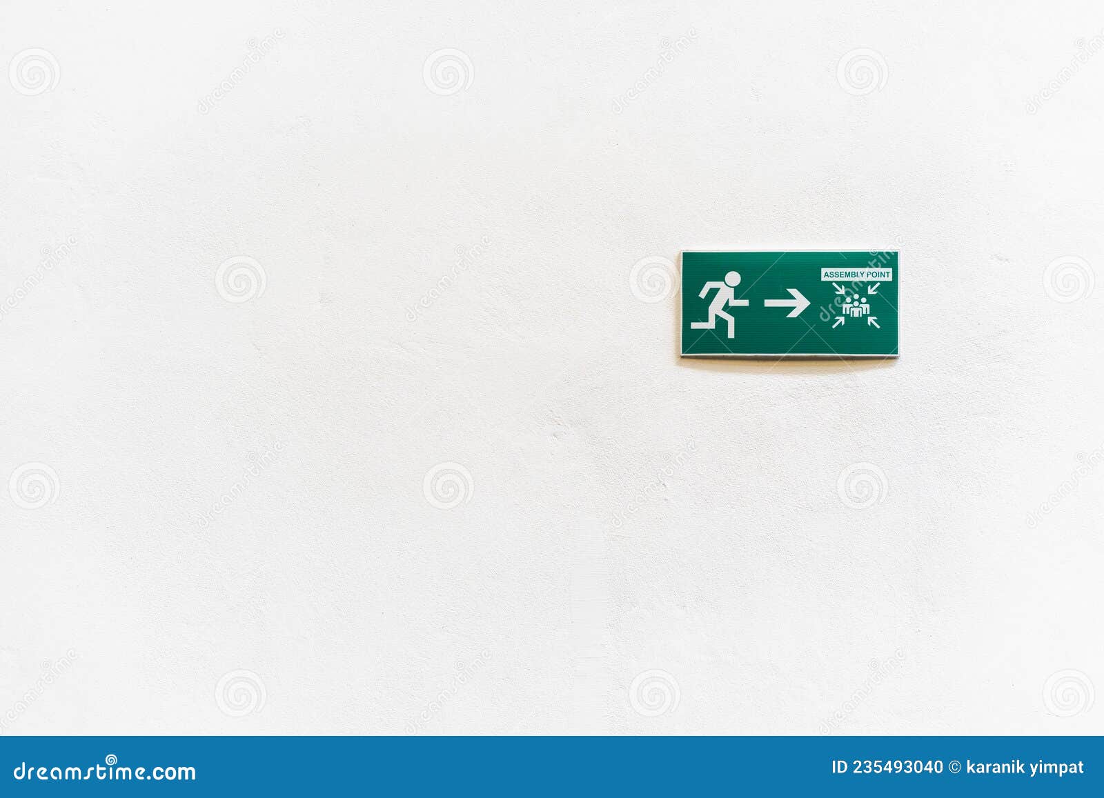 Green Assembly Point Signage on White Concrete Wall Stock Photo - Image ...