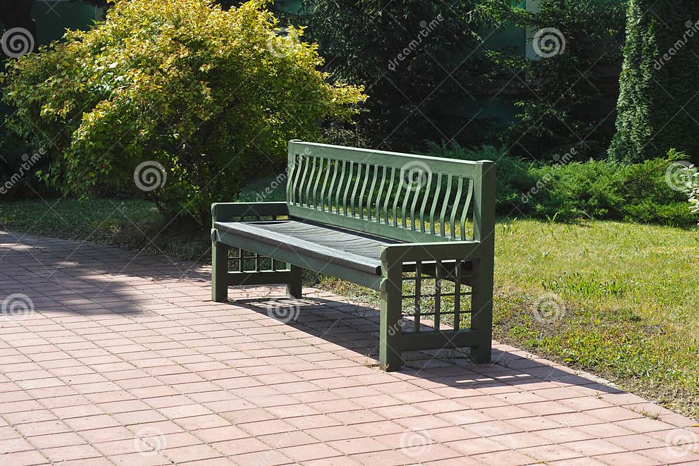 Green Bench Standing in a Park with Green Plants Stock Image - Image of ...