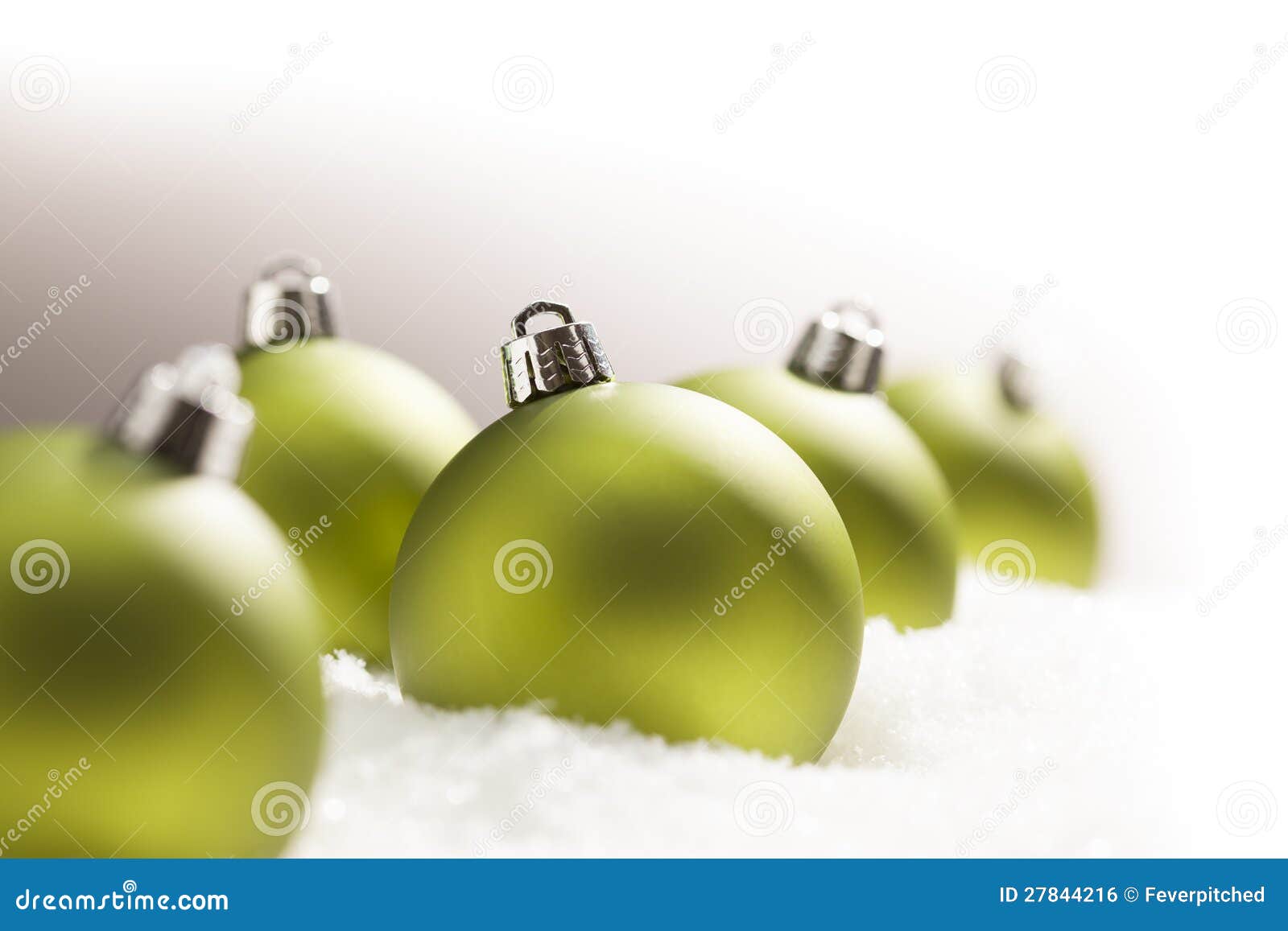 Green Christmas Ornaments on Snow Over a Grey Background Stock Photo ...