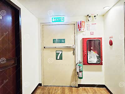 Green Emergency Exit Sign and Fire Extinguisher at Building. Fire Exit ...