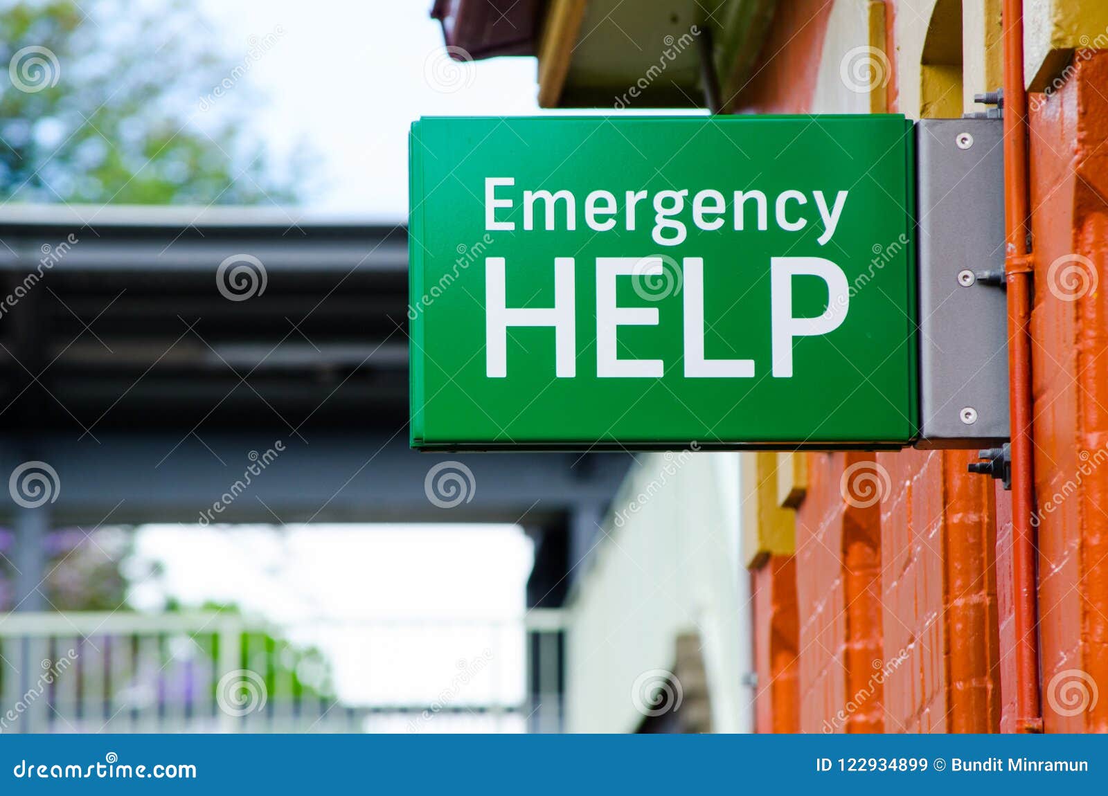 Green Emergency Help Sign Hanging from an Orange Wall. Stock Image ...