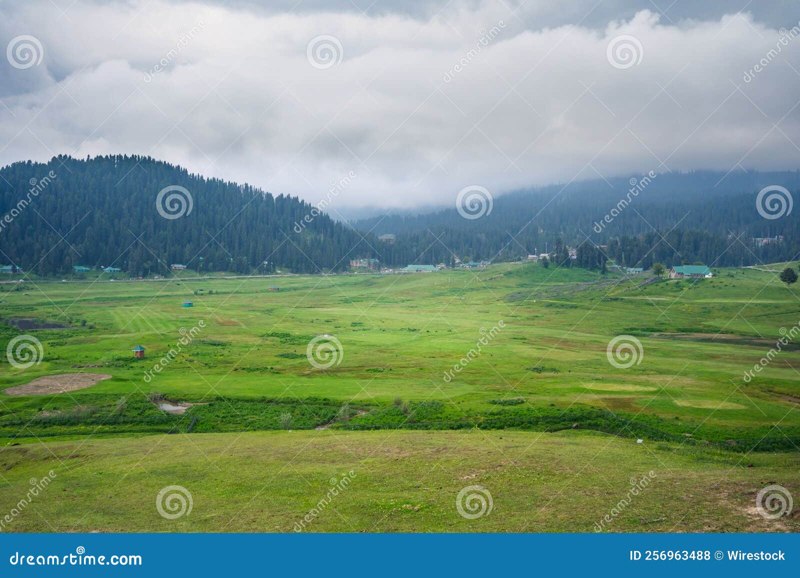 Green Field with Mountains and Cloudy Sky on the Background Stock Photo ...