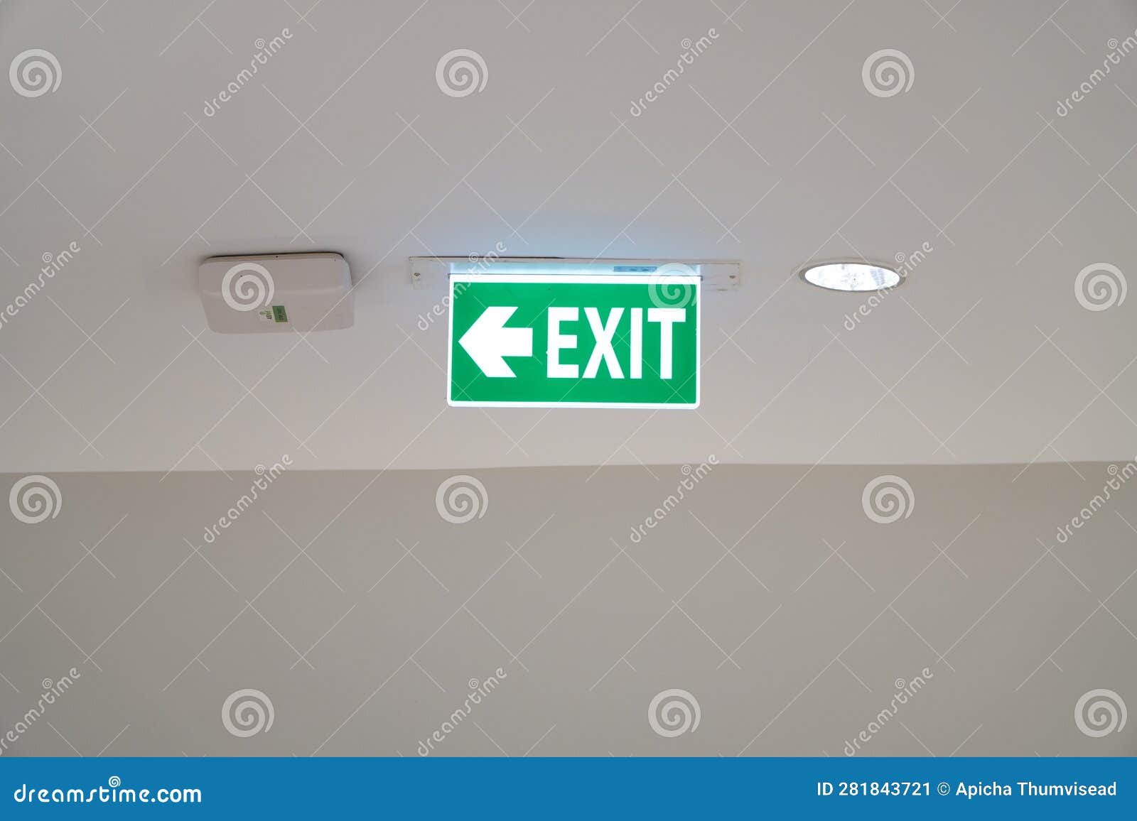 Green Fire Exit Sign Hangs on the Ceiling of the Building. Stock Image ...