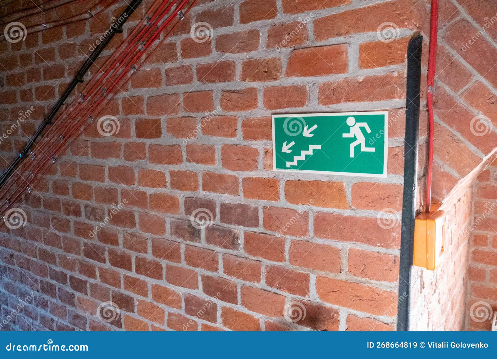 A Green Fire Exit Sign through the Staircase To the Bottom is Placed on ...