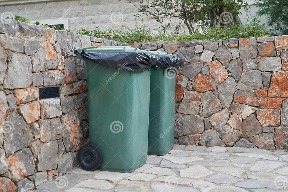 Green Garbage Cans Next To the Stone Wall Stock Image - Image of ...