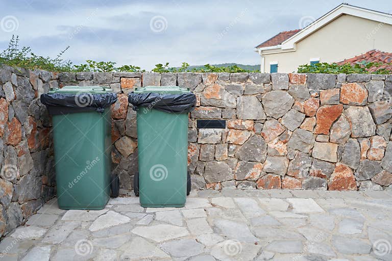 Green Garbage Cans Next To the Stone Wall Stock Image - Image of ...