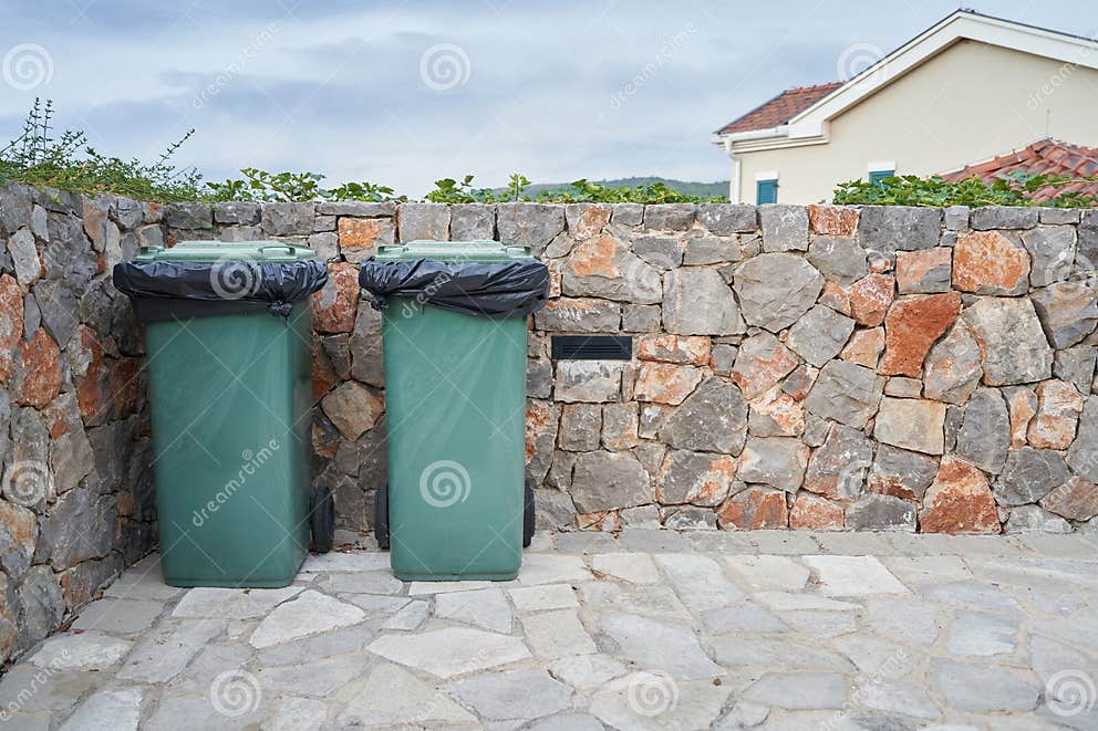 Green Garbage Cans Next To the Stone Wall Stock Image - Image of ...