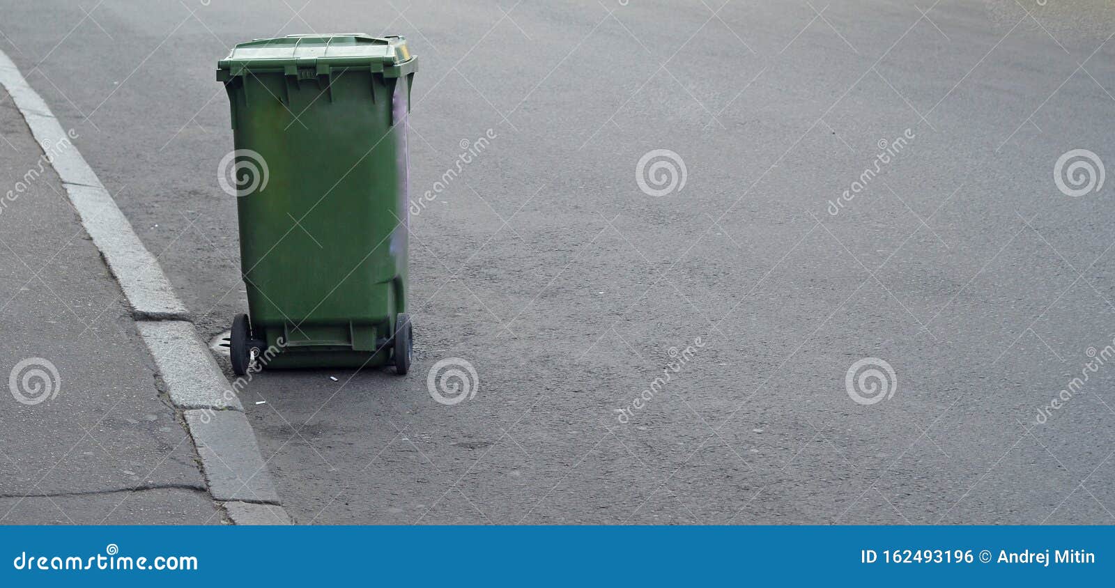Green Garbage Container Near the Pavement on the Street Stock Photo ...