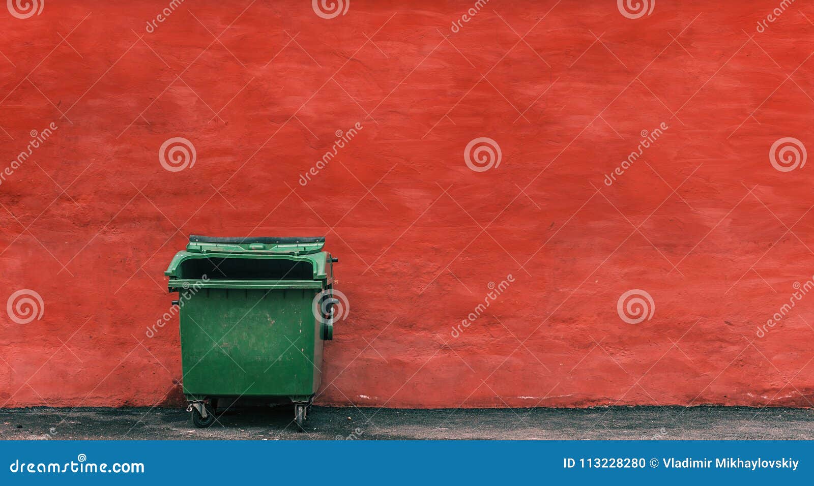 Green Garbage Container on a Red Wall Background Stock Photo - Image of ...