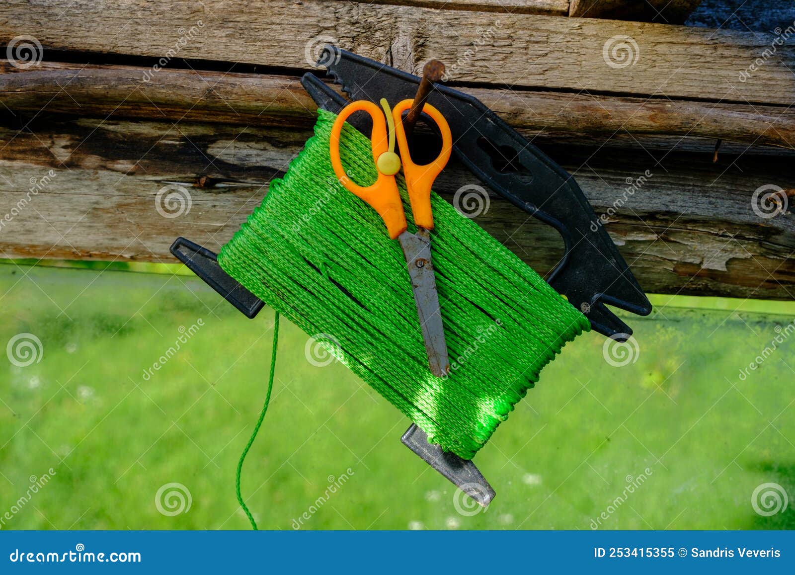 Green Garden String on a Spool and Scissors with Orange Handles Hung on ...