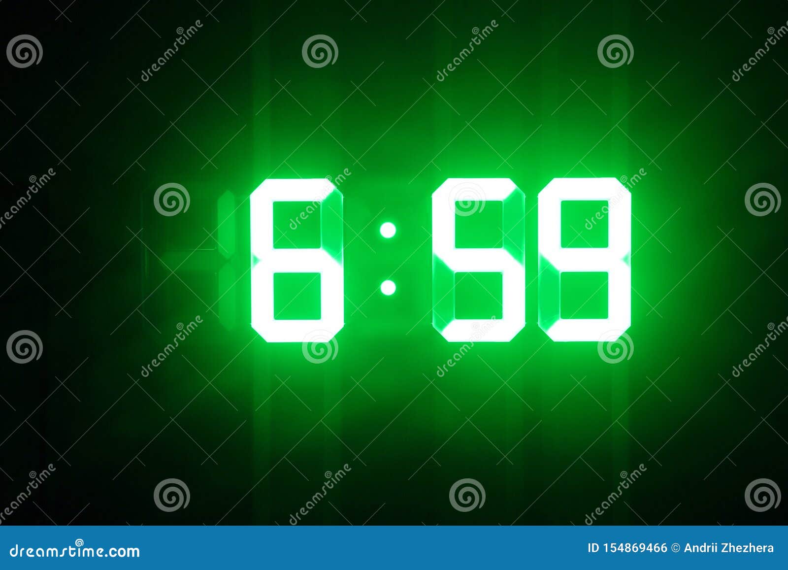 Green Glowing Digital Clocks in the Dark Show 6:59 Time Stock Photo ...