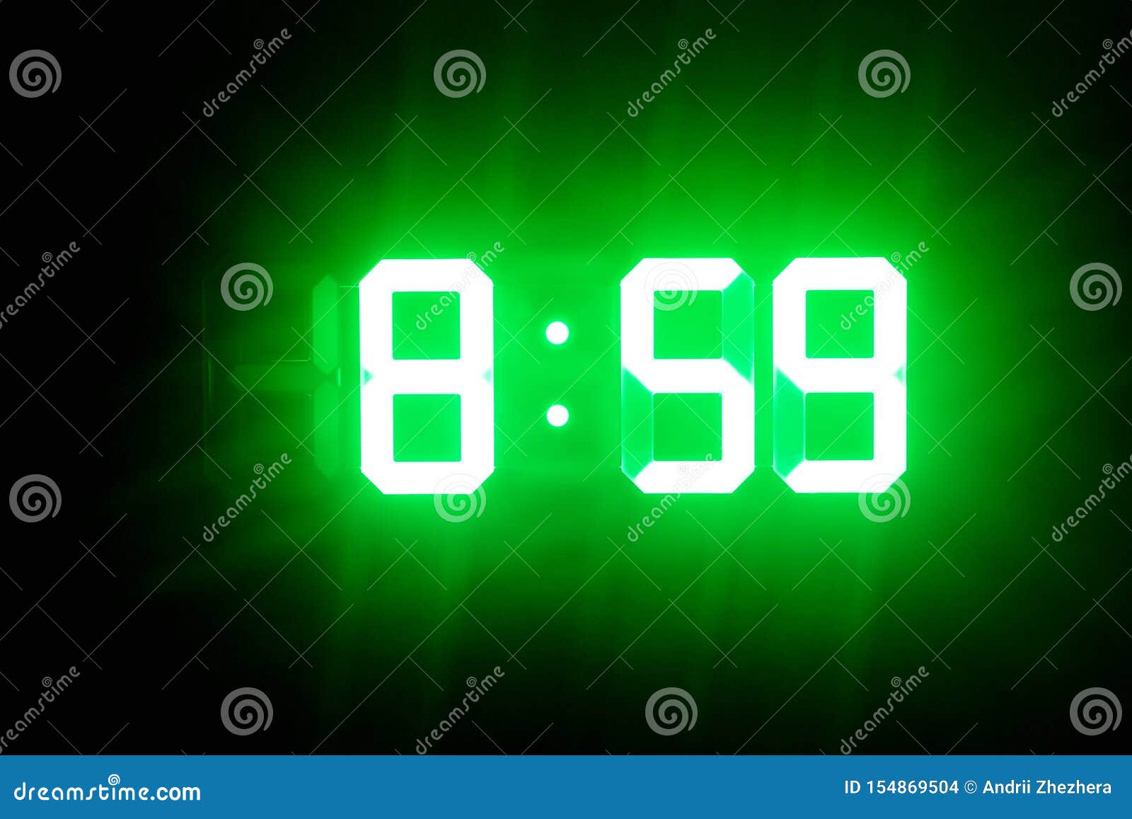 Green Glowing Digital Clocks in the Dark Show 8:59 Time Stock Photo ...