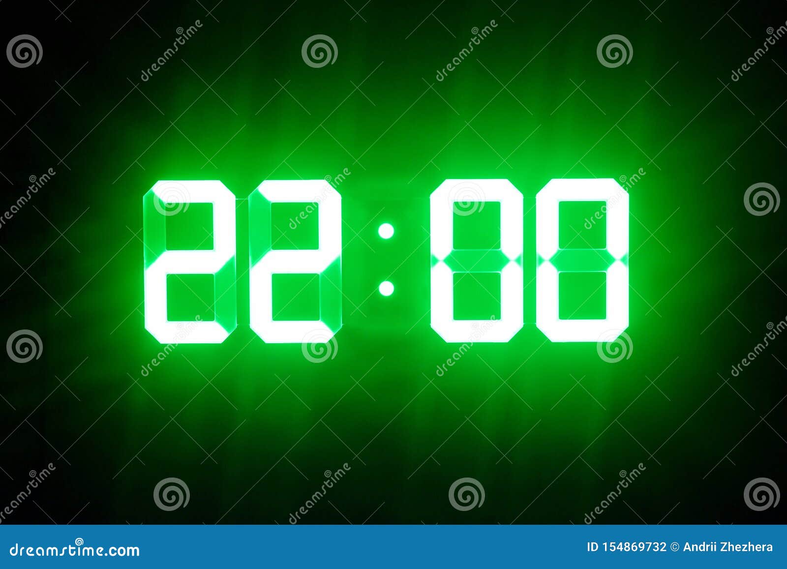 Green Glowing Digital Clocks in the Dark Show 22:00 Time Stock Photo ...