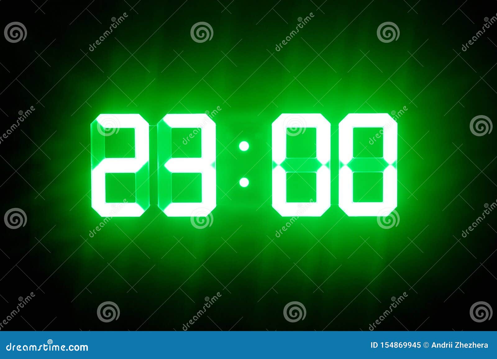 Green Glowing Digital Clocks in the Dark Show 23:00 Time Stock Image ...