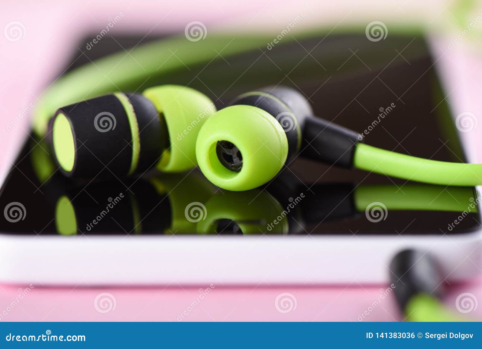 Green Headphones on the Smartphone Screen. Reflection of Headphones on ...