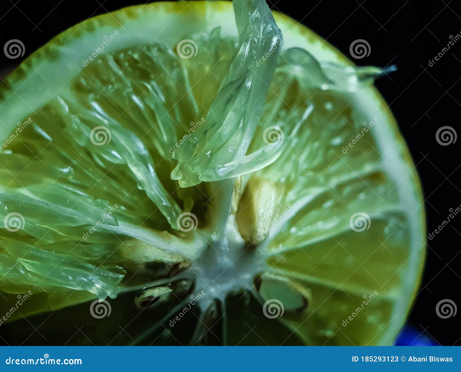 A Green Lemon is Cut in the Middle and the Seed and Lemon Juice in the ...