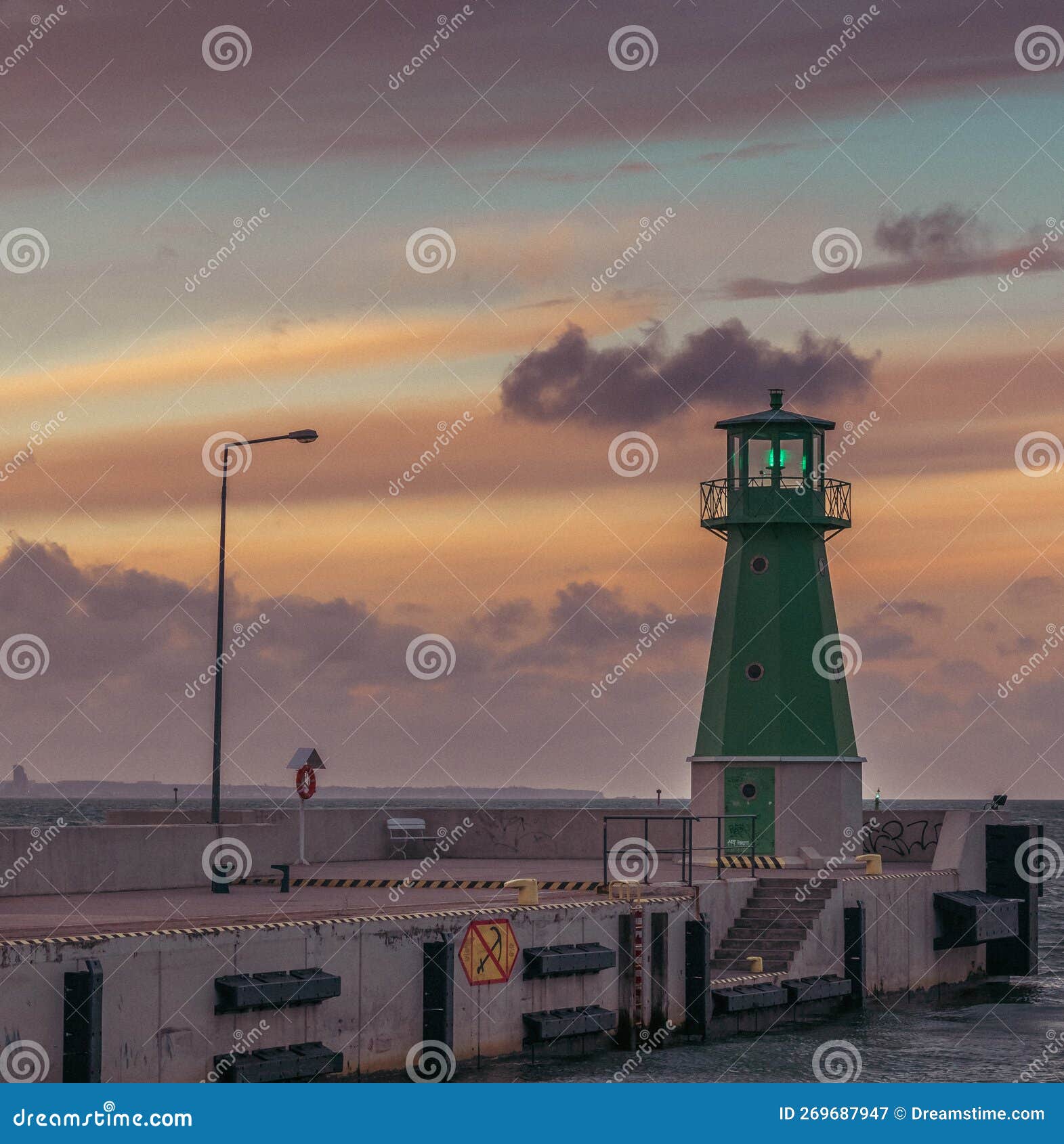 Green lighthouse at sunset stock image. Image of horizon - 269687947