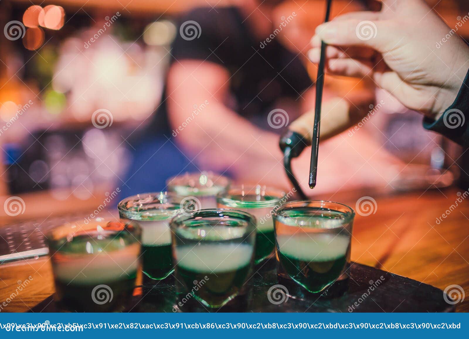Green Liquid in Shot Glasses Standing on the Counter. Bartender Tastes ...