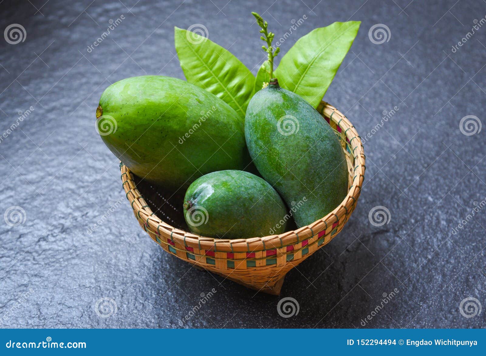 Green Mango Summer Fruit and Green Leaves in the Basket on Dark ...