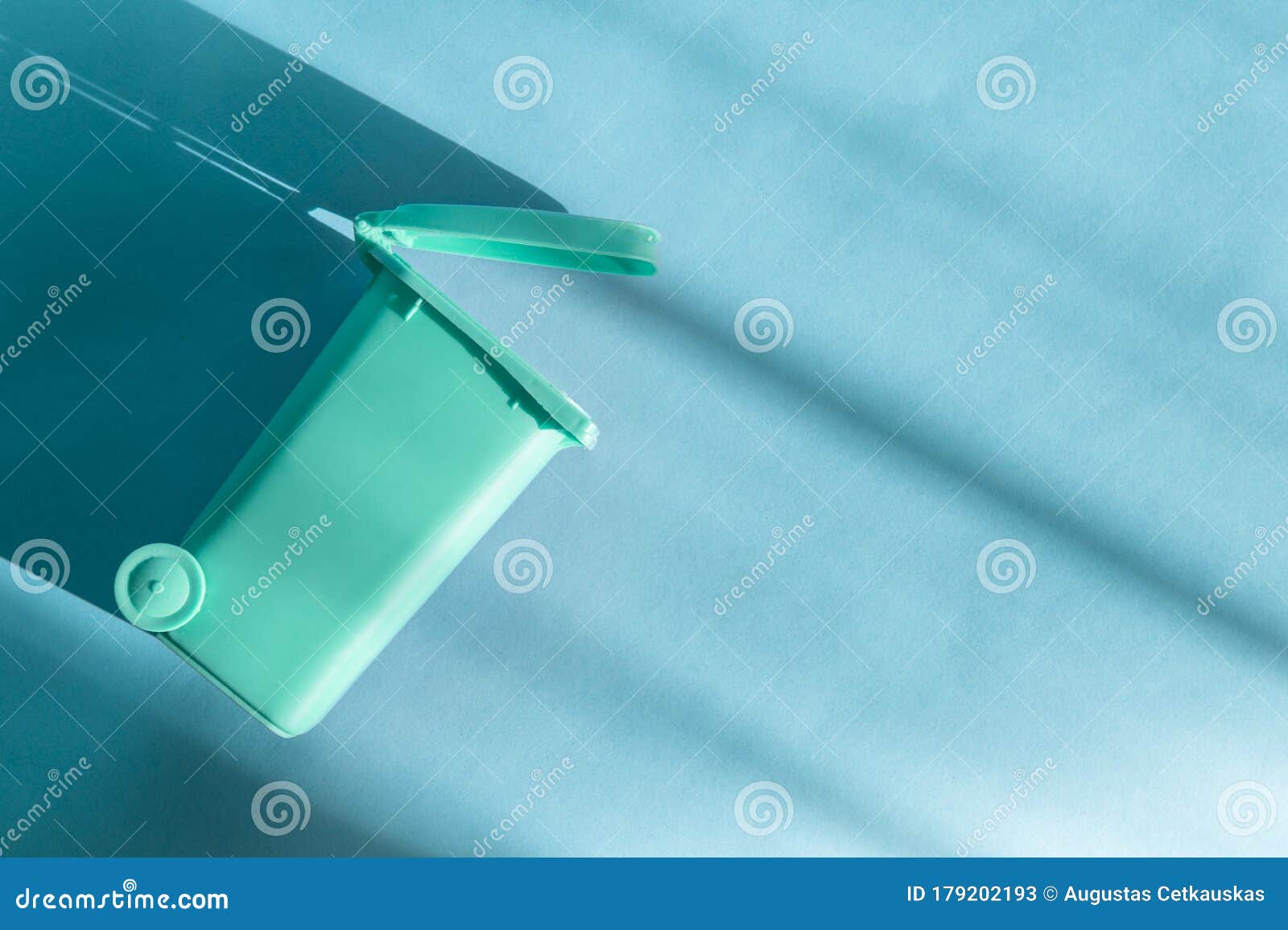 A Green Plastic Garbage Bin on Blue Background, Great for Recycling ...