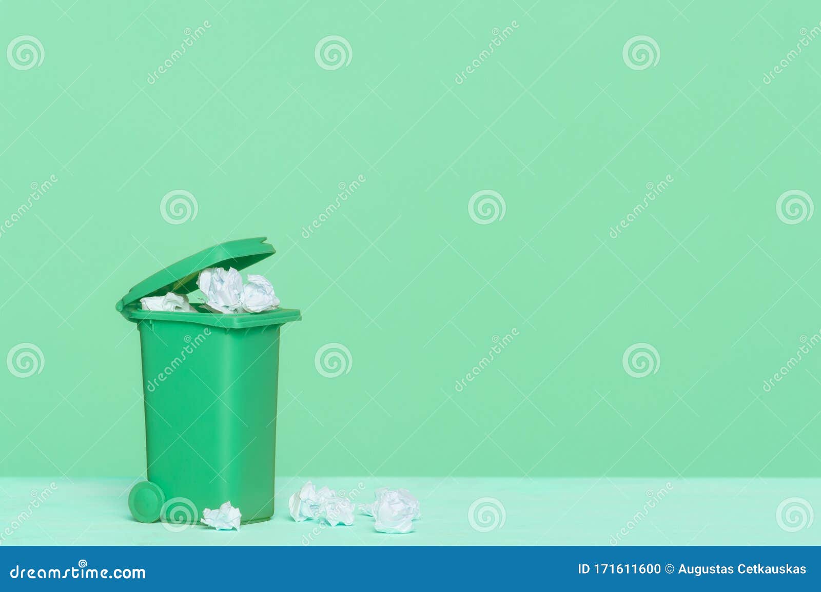 A Green Plastic Garbage Bin and Paper on Green Background, Great for ...
