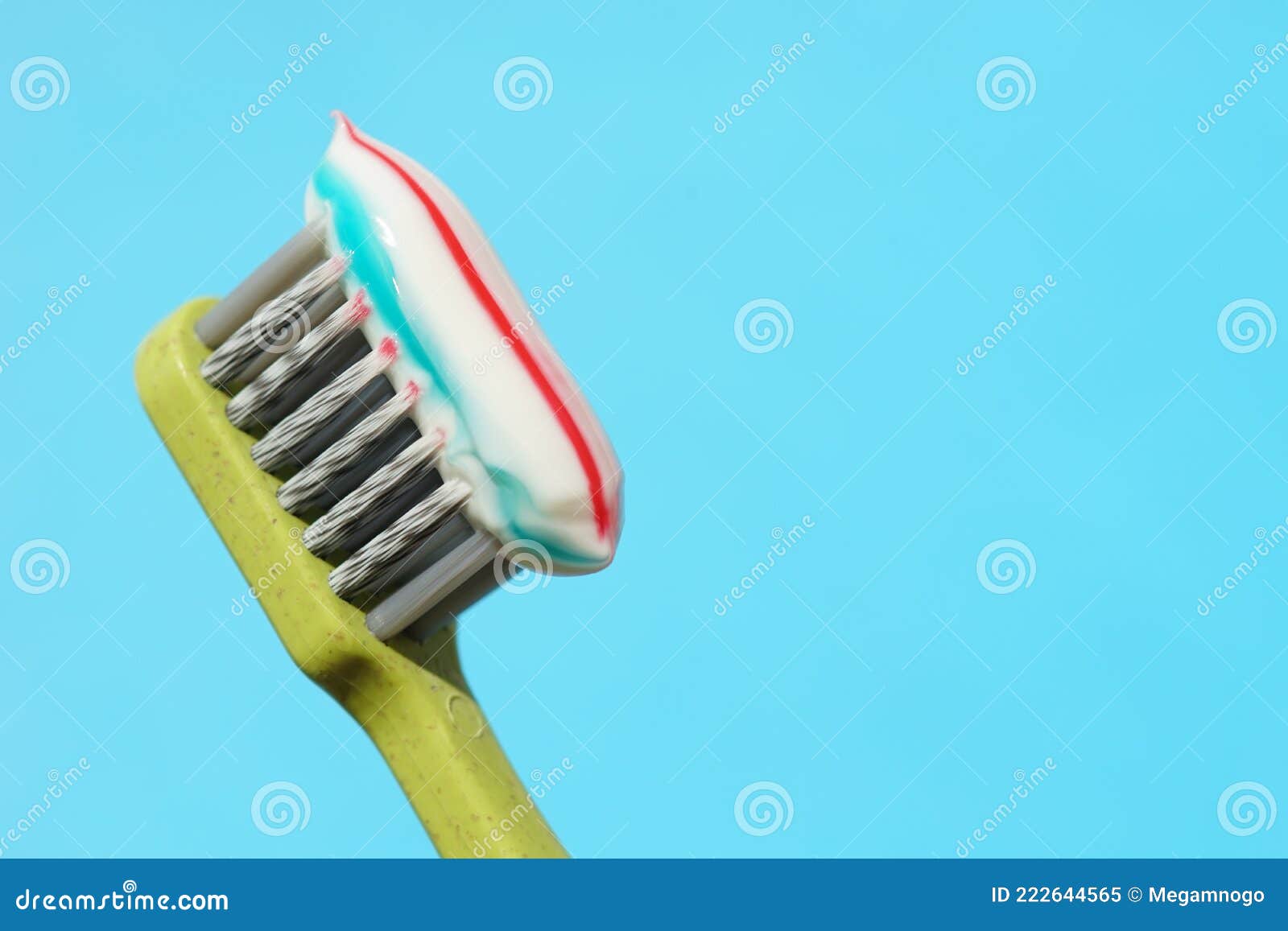 Green Plastic Toothbrush with Striped Toothpaste on Blue Table Stock ...
