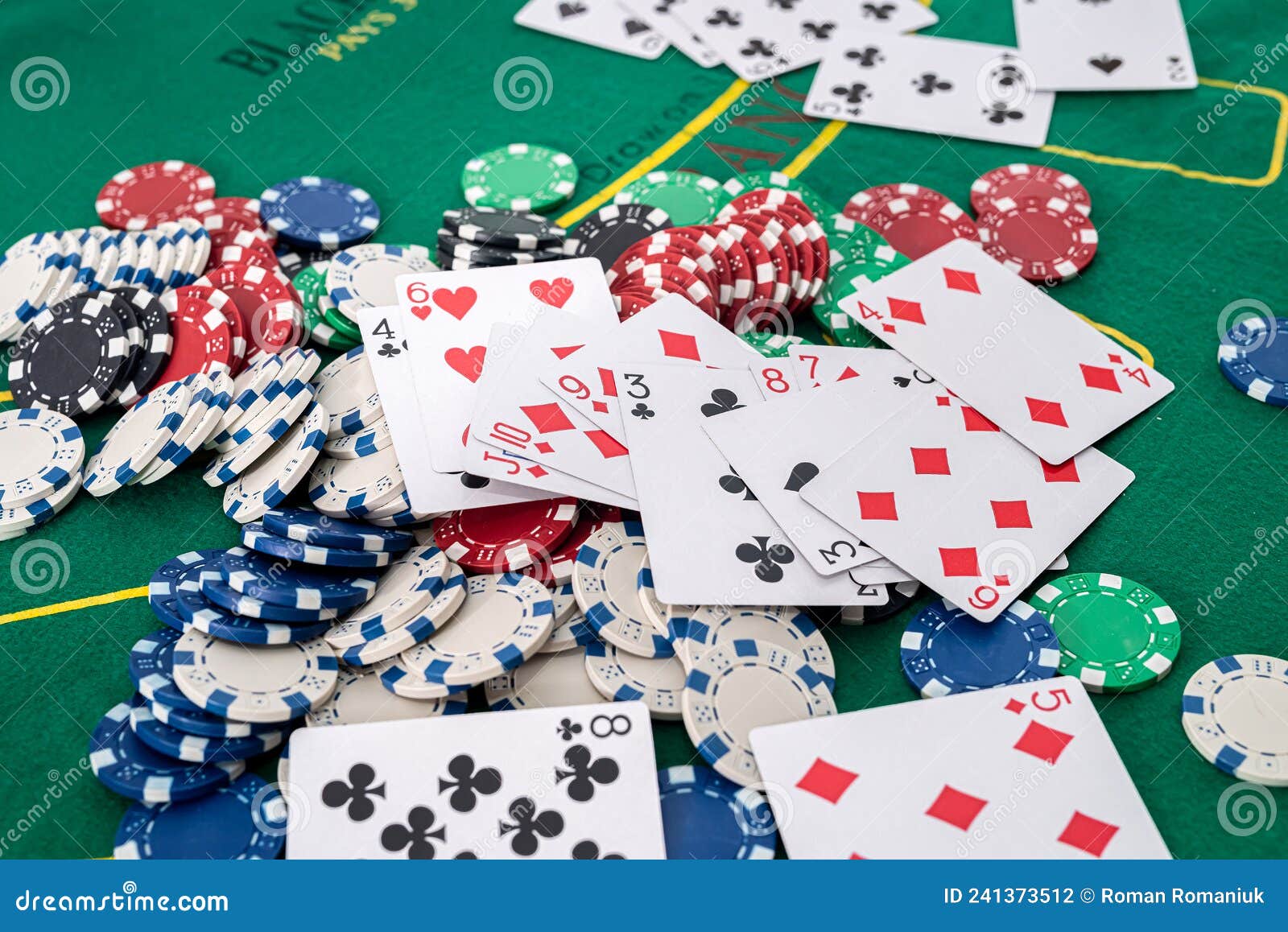On the Green Poker Table are Playing Cards, and Lots of Colored Chips ...