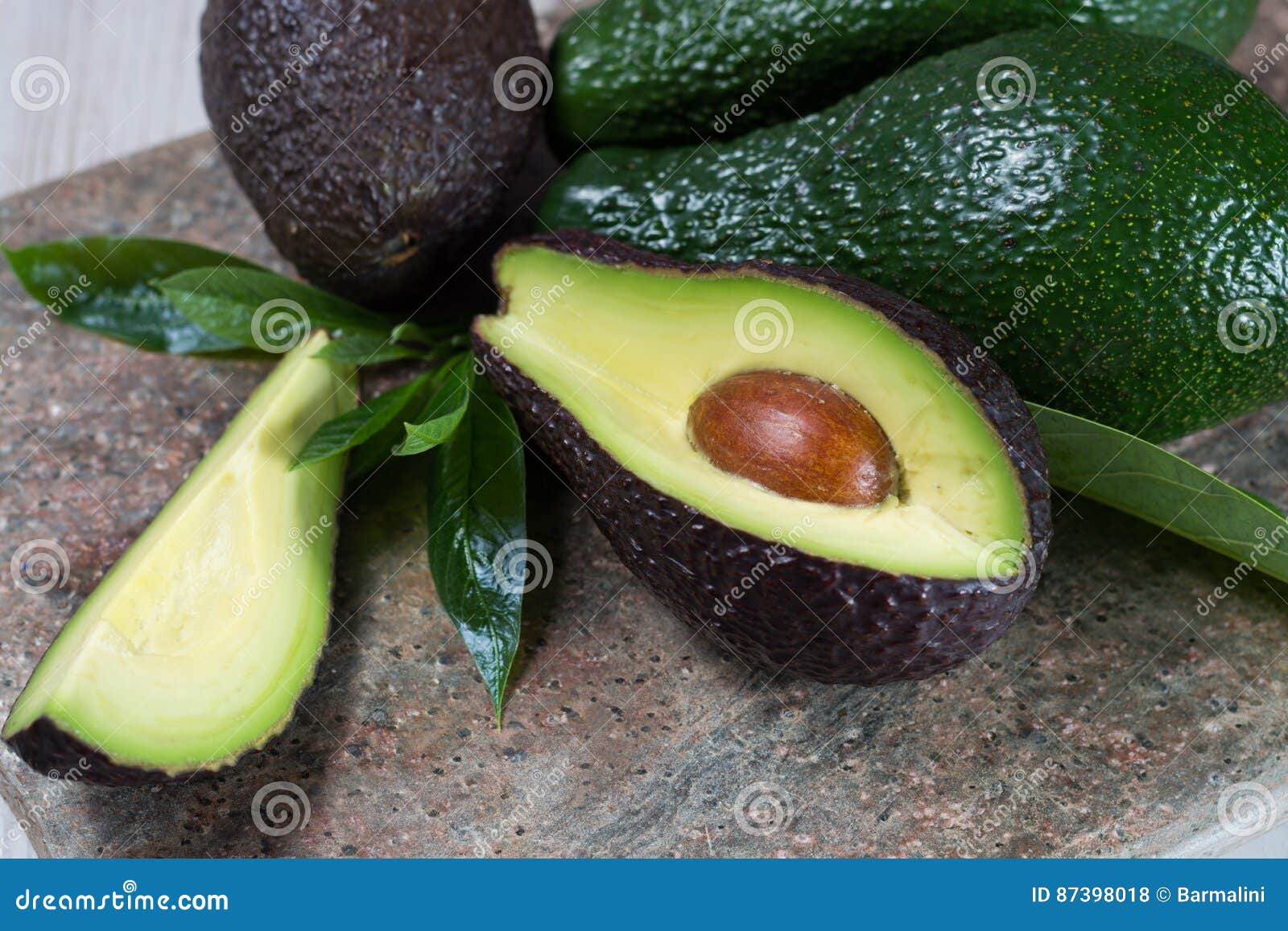 Green Ripe Avocado with Leaves on Granite Plank Stock Photo - Image of ...