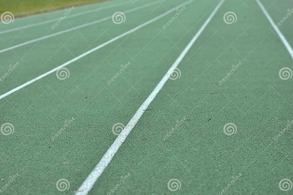 Green Running Track with White Lines and Green Grass Stock Photo ...