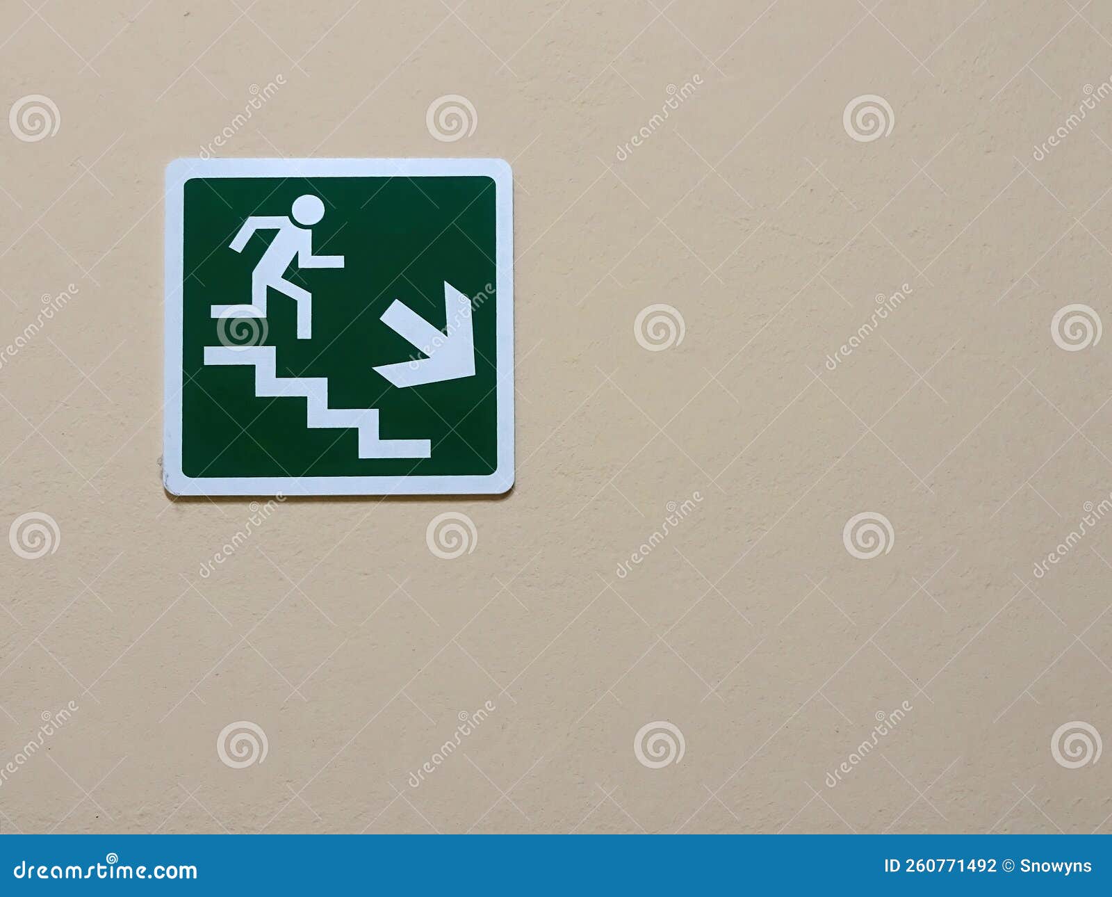 Green Sign Down the Stairs on a Bright Wall - Direction To the ...