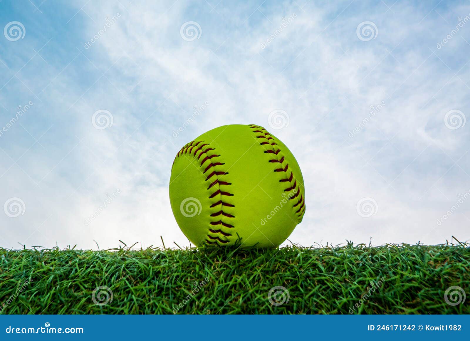 A Green Softball on the Grass with a Blue Sky in the Background Stock ...