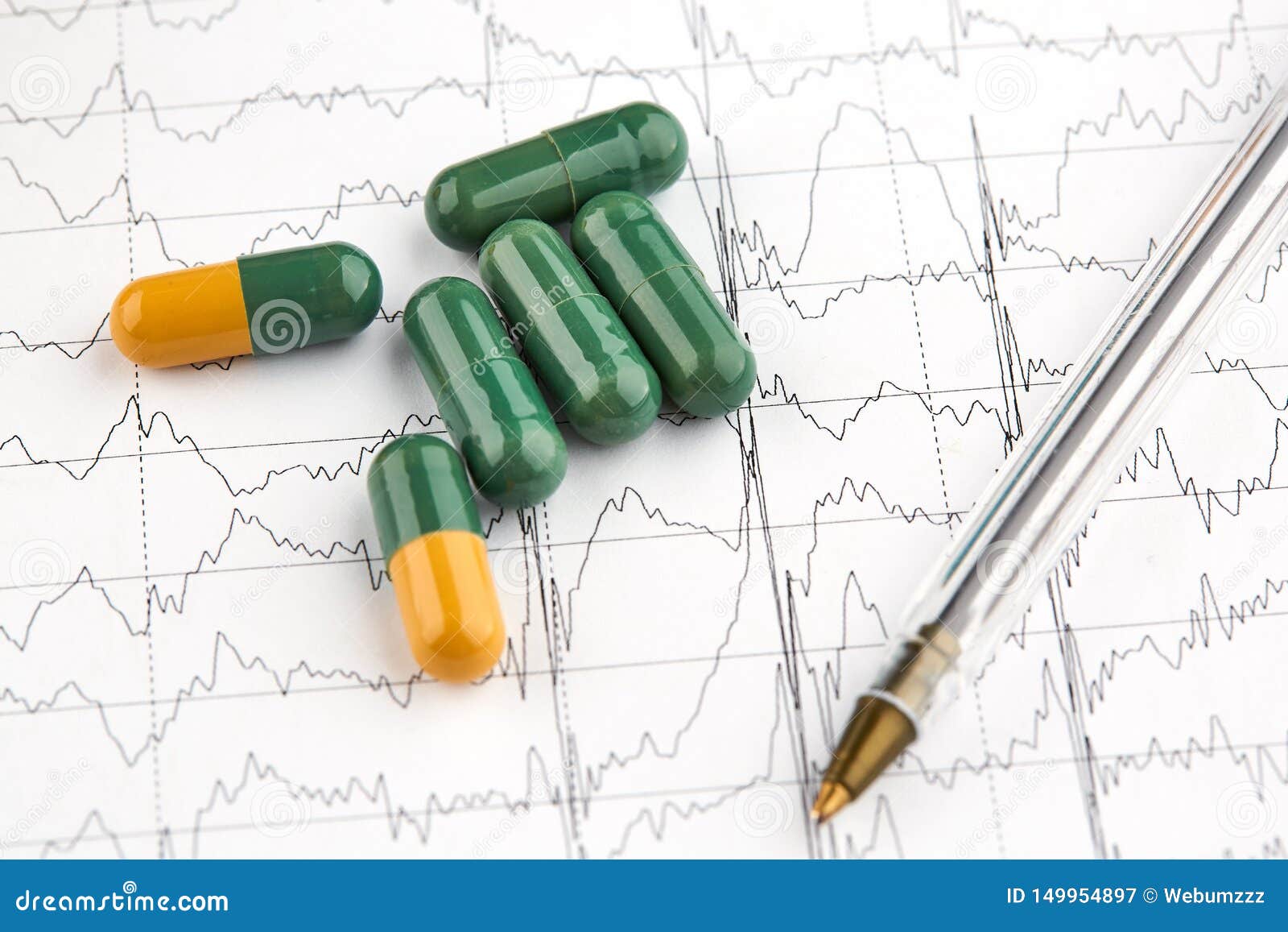 Green and Yellow Capsules and Pen on EKG Graph Stock Image - Image of ...