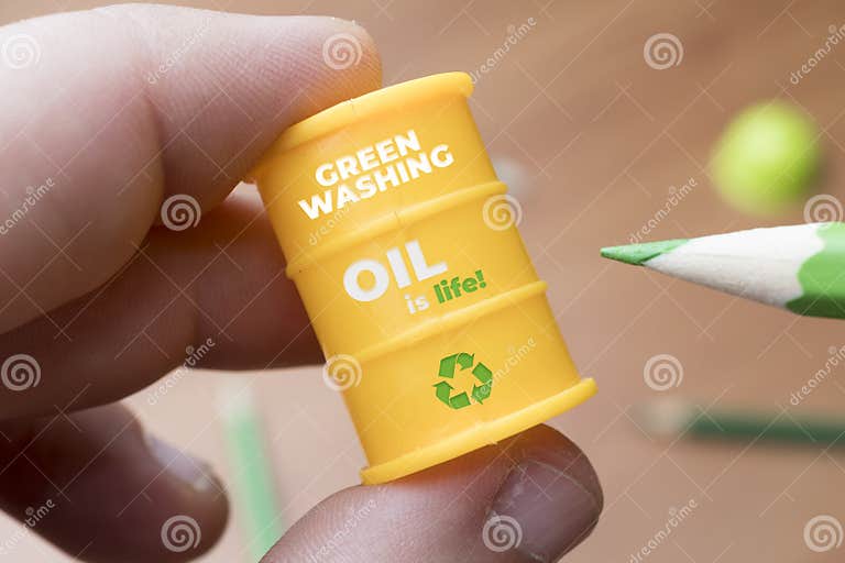 Greenwashing Concept. Man Paints a Barrel of Oil with a Green Pencil ... Greenwashing Concept. Man Paints a Barrel of Oil with a Green Pencil ...