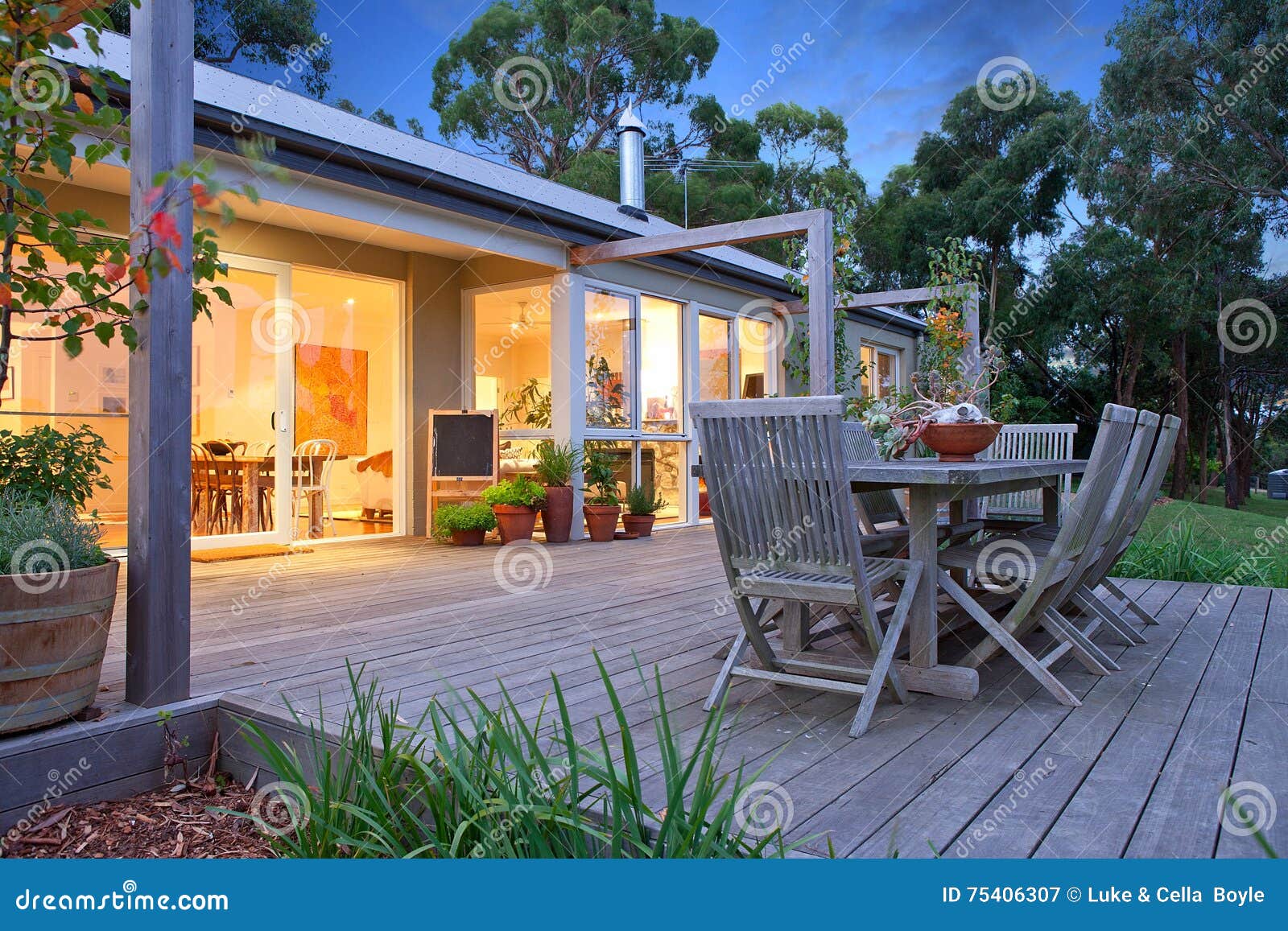 Grey deck and lit house. stock image. Image of dusk, home - 75406307