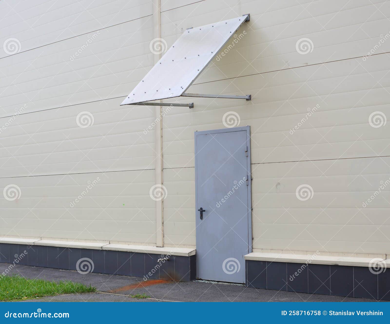 Grey Metal Door with a Slanting Canopy in a Light Wall Stock Photo ...