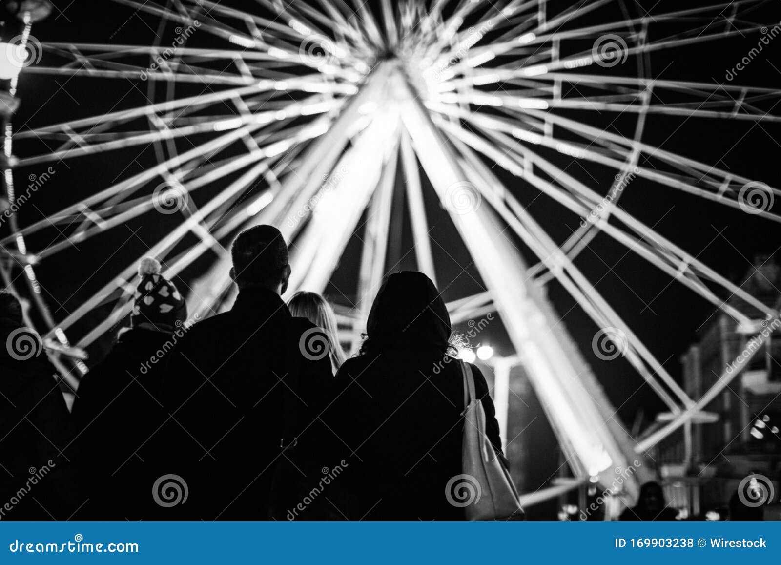 Grey Scale Shot of a Group of People Standing in Front of a Merry Go ...