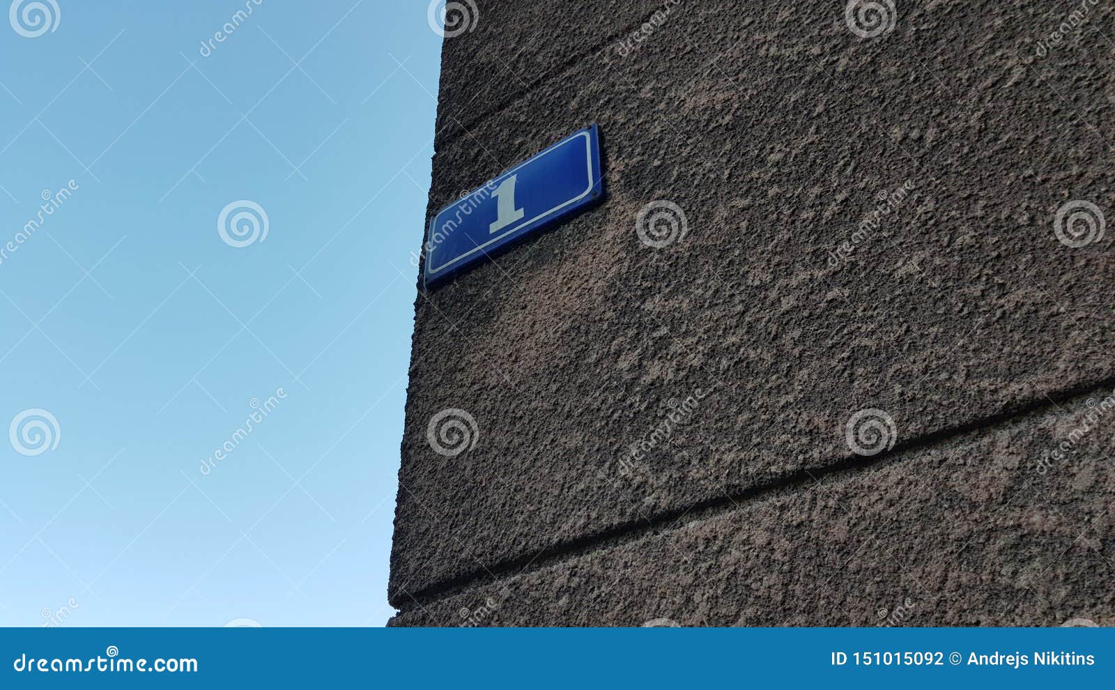 Grey Wall on Blue Sky Background with Number One on it Stock Photo ...
