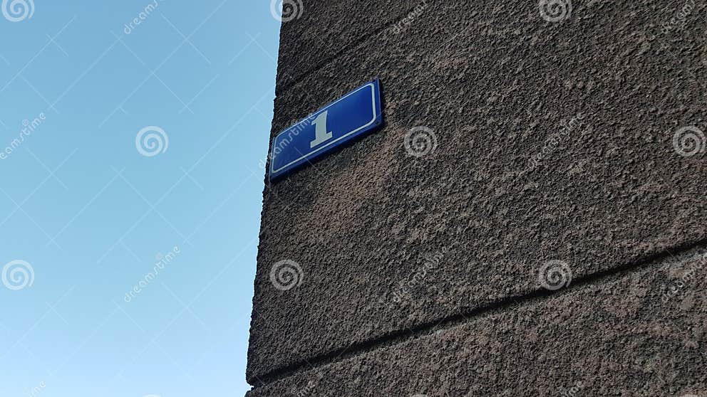 Grey Wall on Blue Sky Background with Number One on it Stock Photo ...