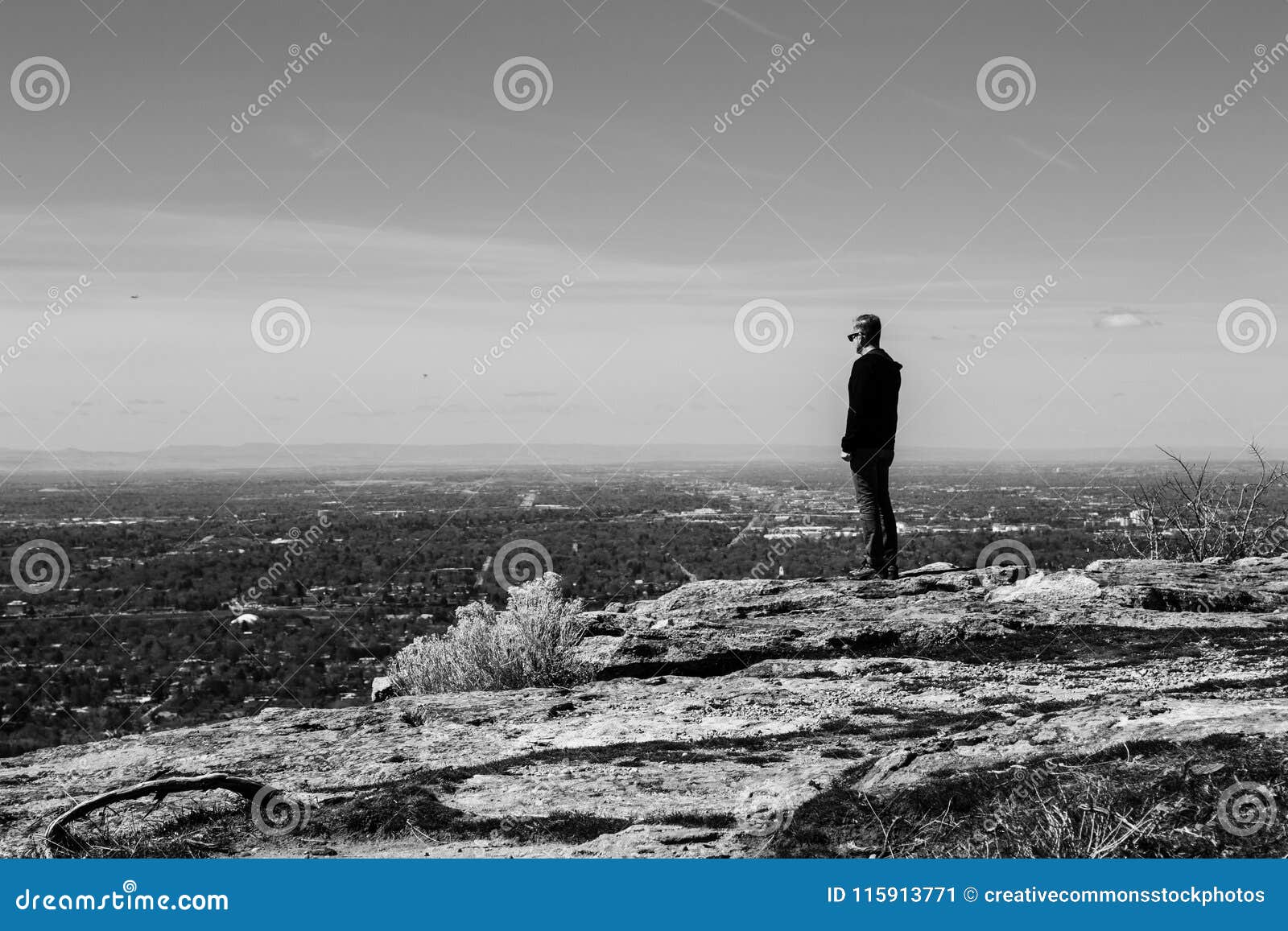 Greyscale Photography Of Man Standing On Cliff In Front Of Building ...