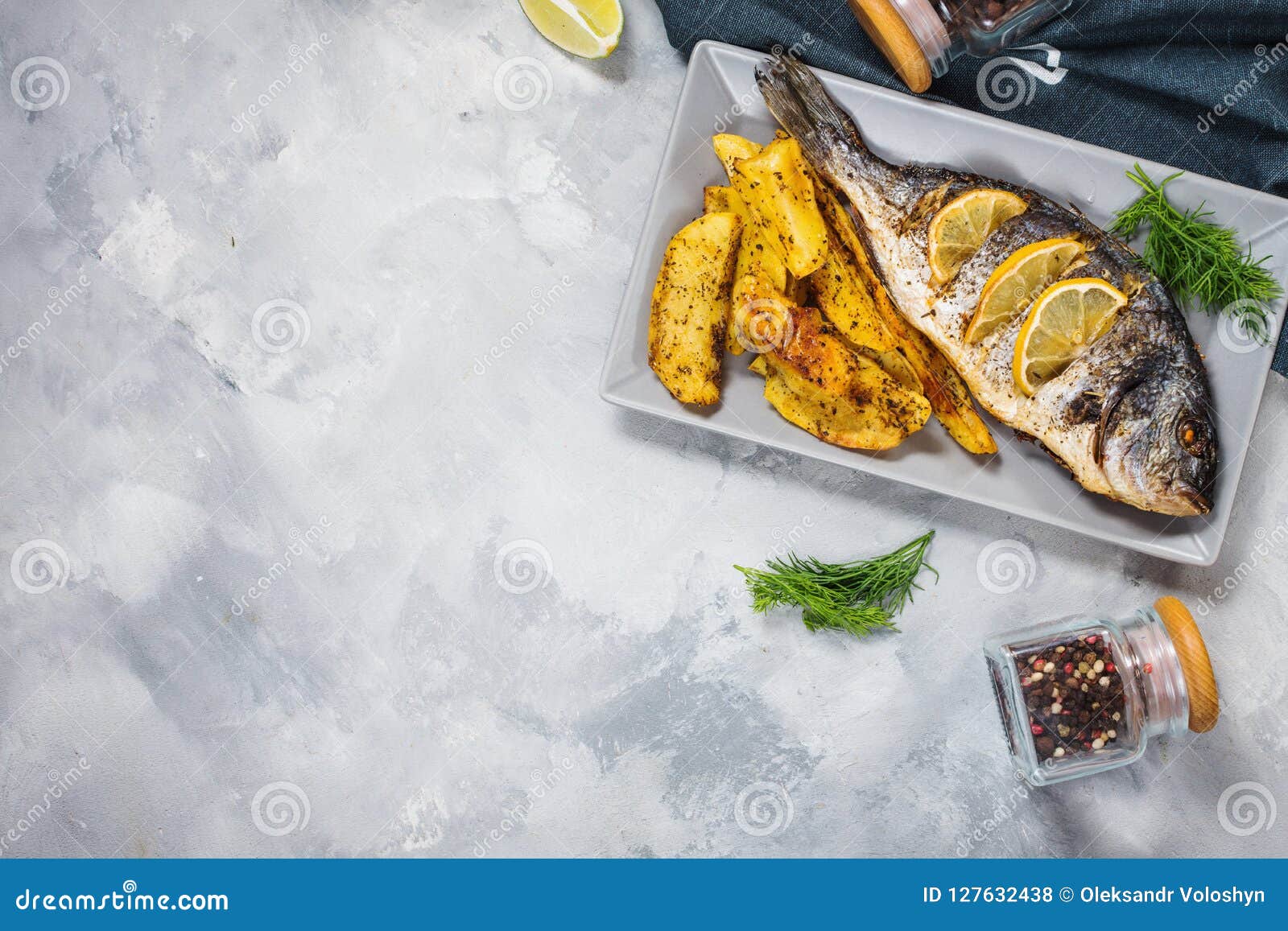 Grilled Fish on Stone Plate with Lemon on Concrete Background, Top View ...