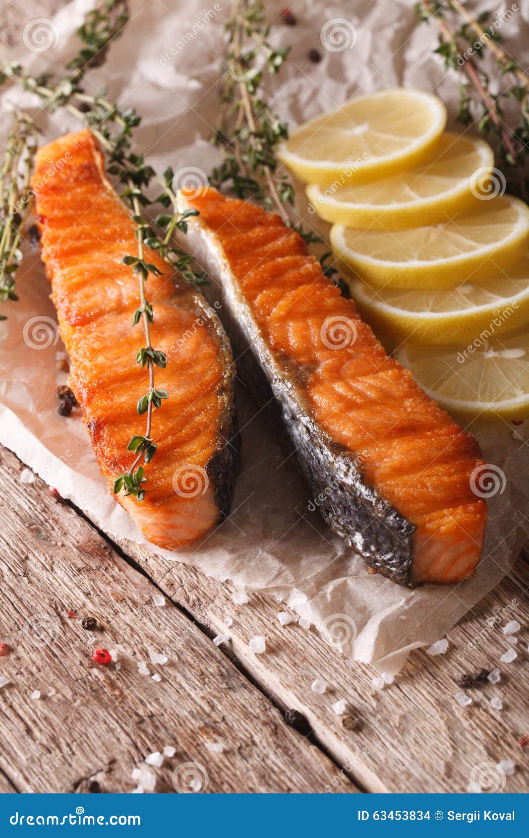 Grilled Salmon with Lemon and Thyme on a Paper Close-up. Vertical Stock ...
