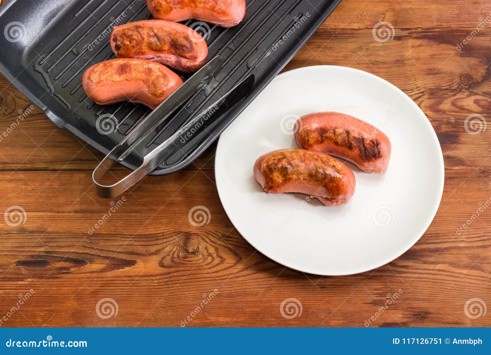 Grilled Sausages on Dish and Grill Pan on Rustic Table Stock Image ...