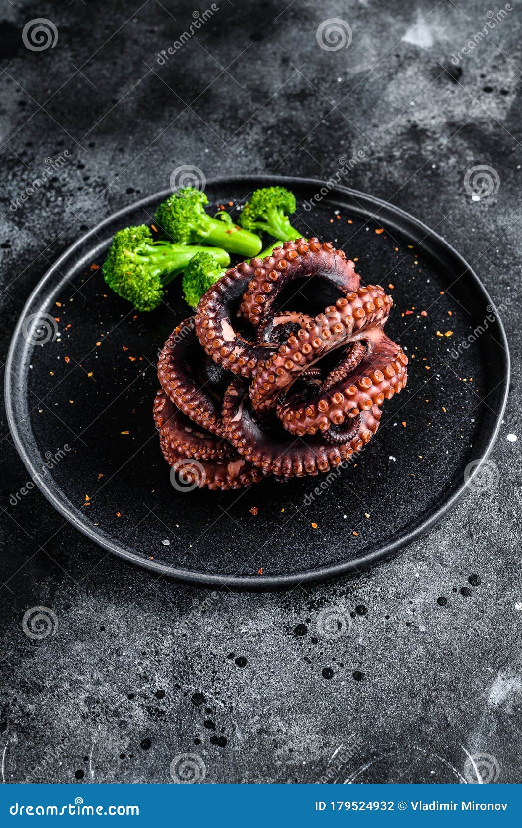 Grilled Whole Octopus with Broccoli on a Plate. Black Background Stock ...