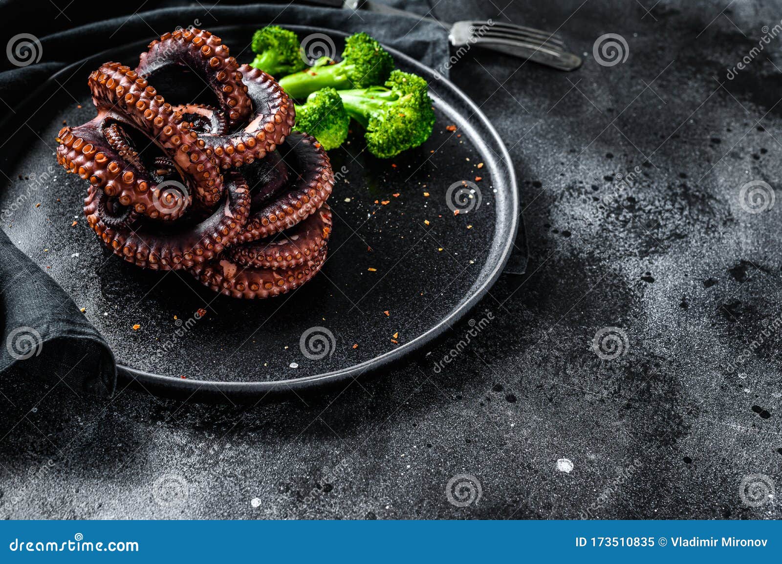 Grilled Whole Octopus with Broccoli on a Plate. Black Background. Top ...