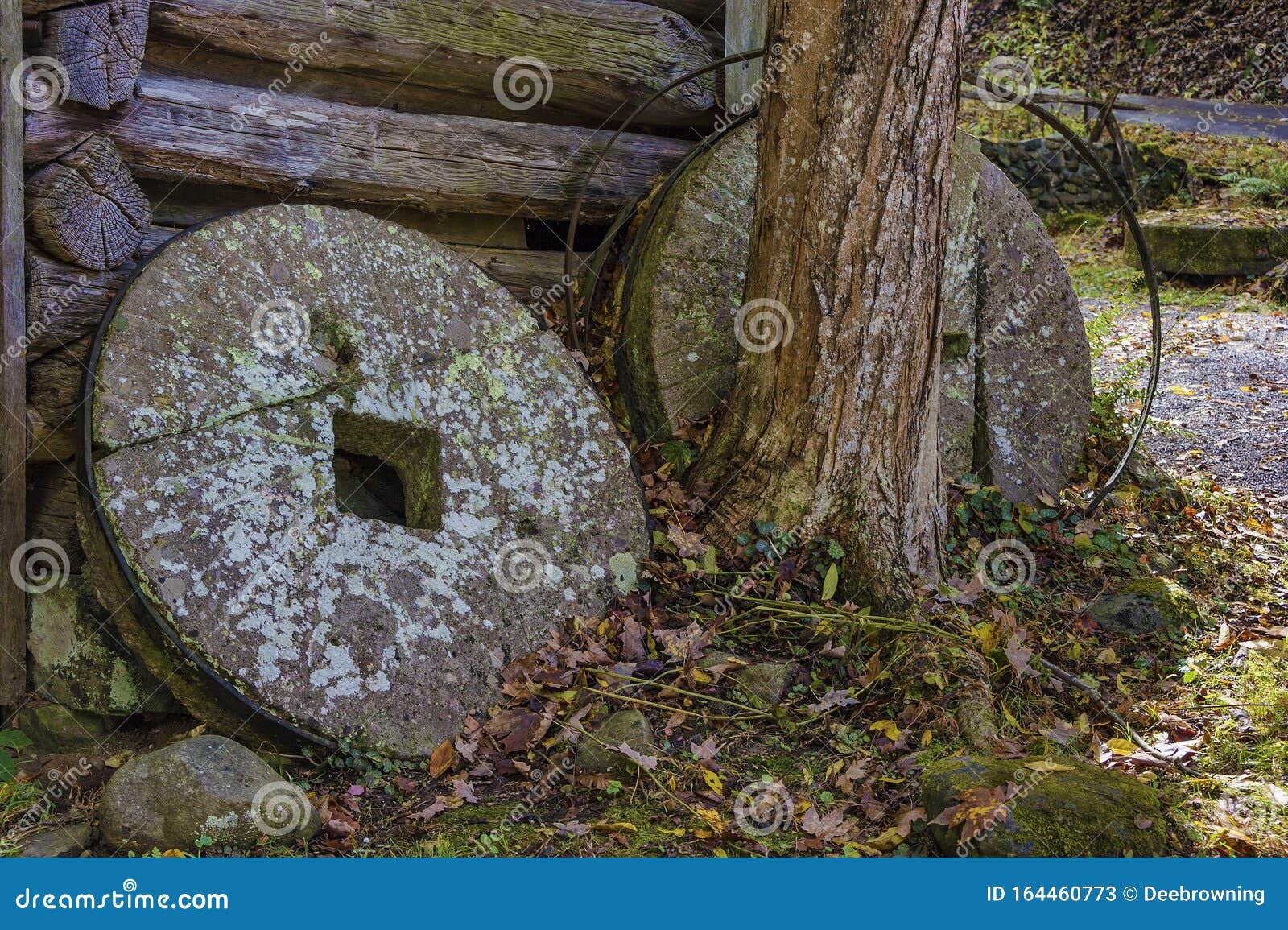 Gristmill Stones Leaned Up Against a Log Structure Stock Image - Image ...
