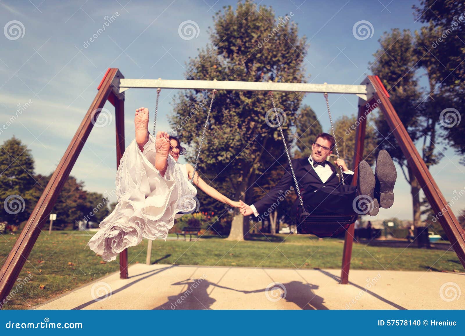 Groom and Bride Having Fun on a Swing Set Stock Photo - Image of blond ...