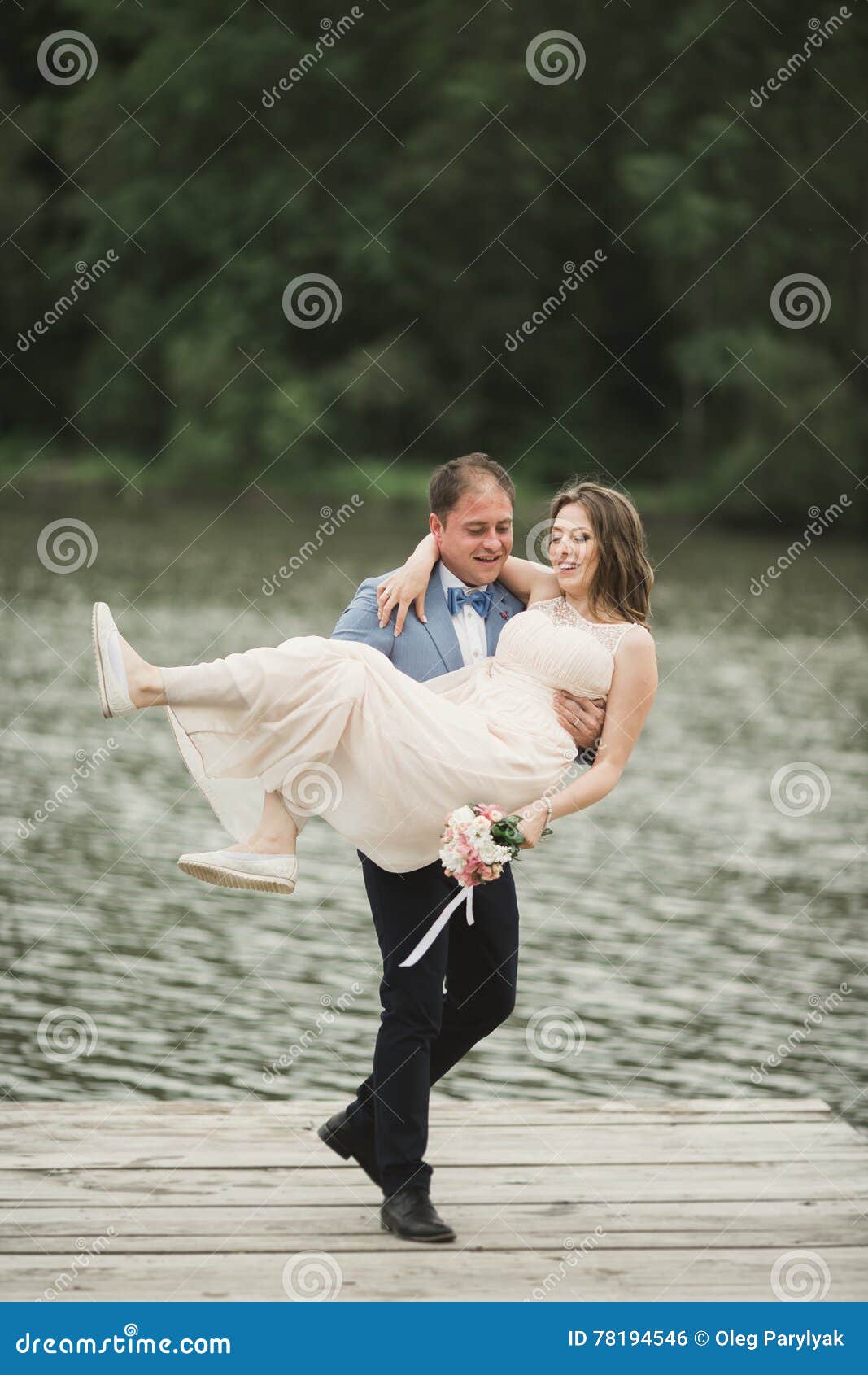 Groom Carrying Bride Near Lake and Forest Stock Photo - Image of carry ...