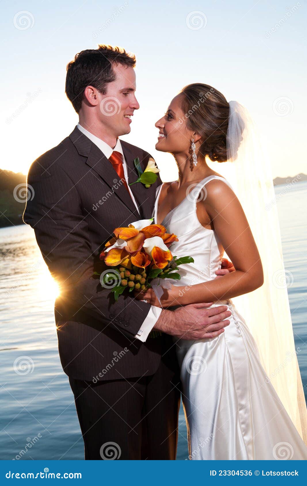 Groom Holding Bride at Sunset with Sunburst Stock Photo - Image of ...